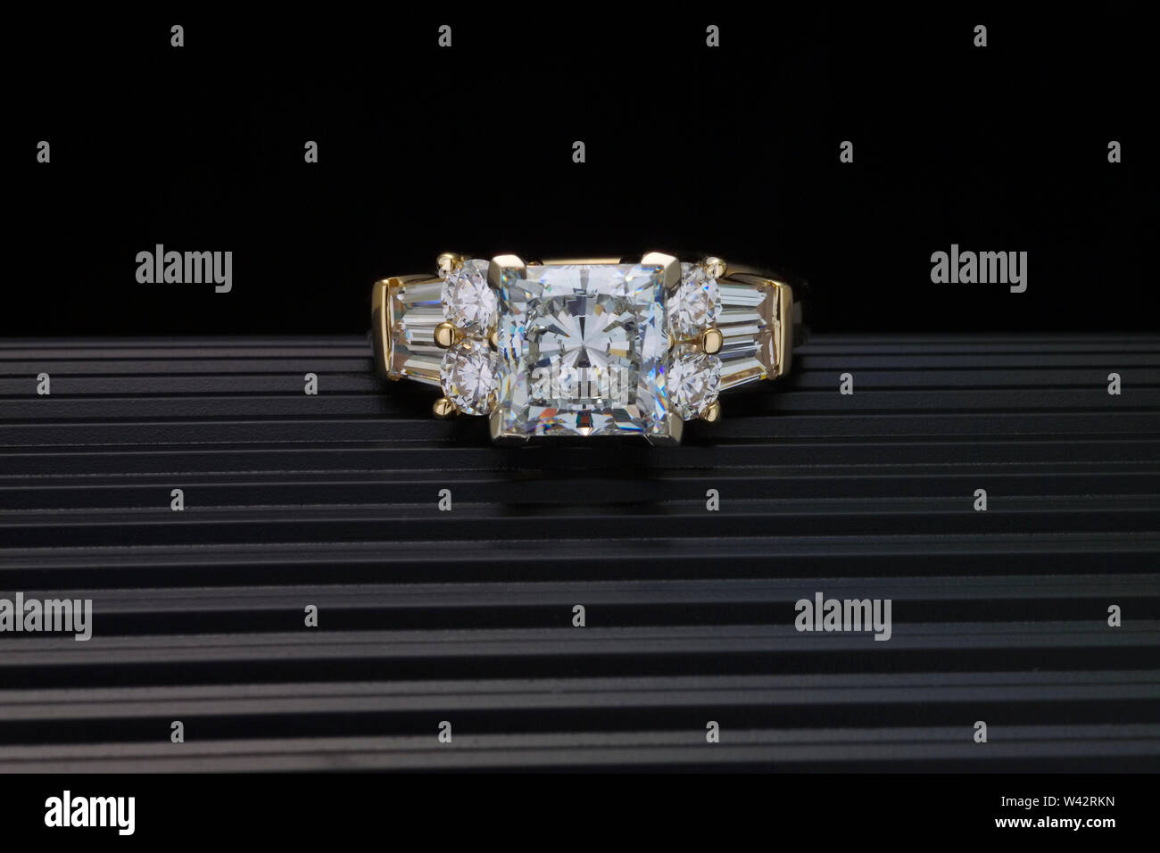 In this ring a large square diamond is flanked by round and bar cut ...