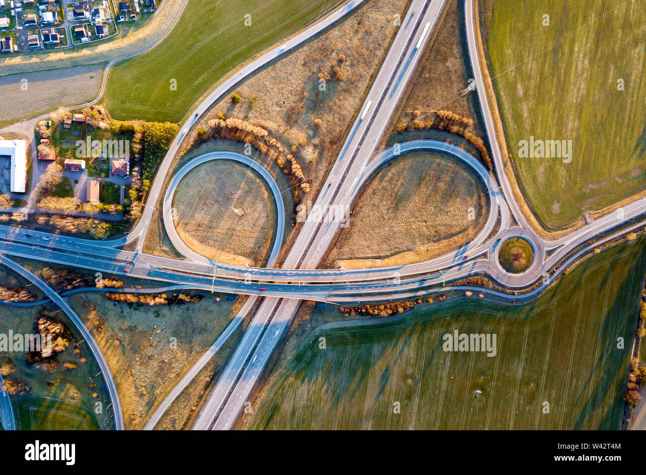Aerial top view of modern highway road intersection, house roofs on ...