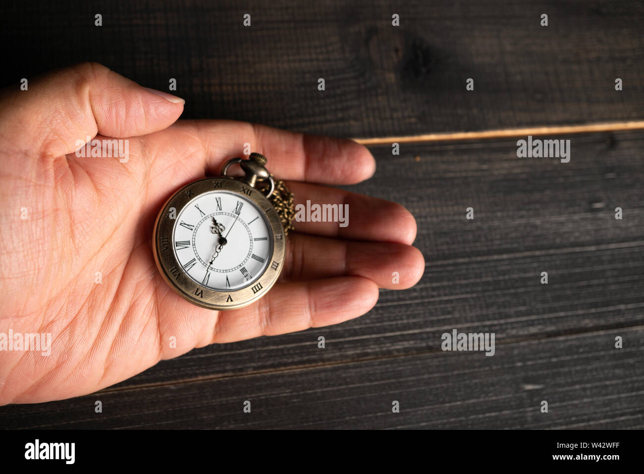 Men hands hold a pocket watch and a black background Stock Photo - Alamy