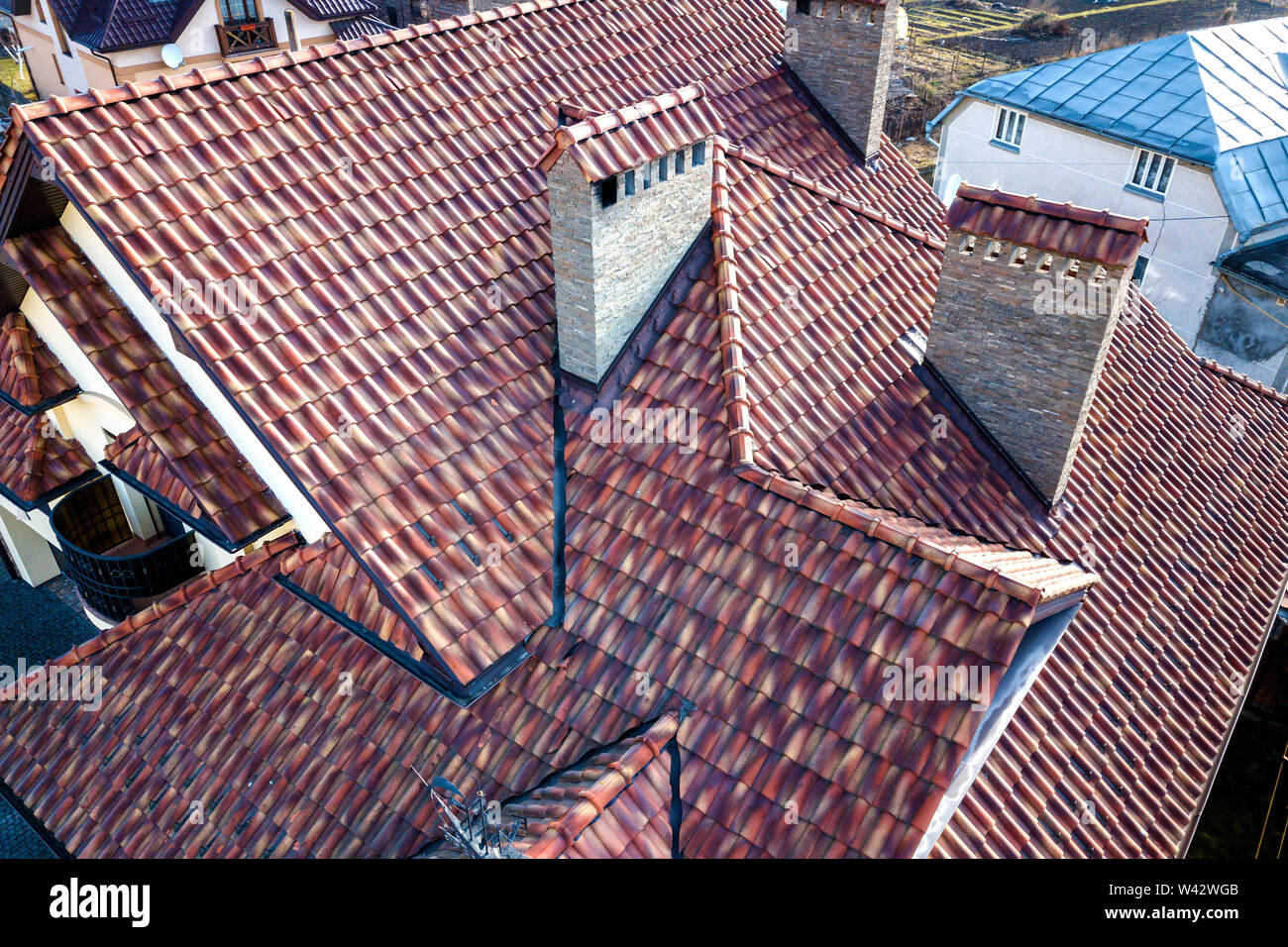 Aerial top view of complex house metal shingle roof and high brick ...