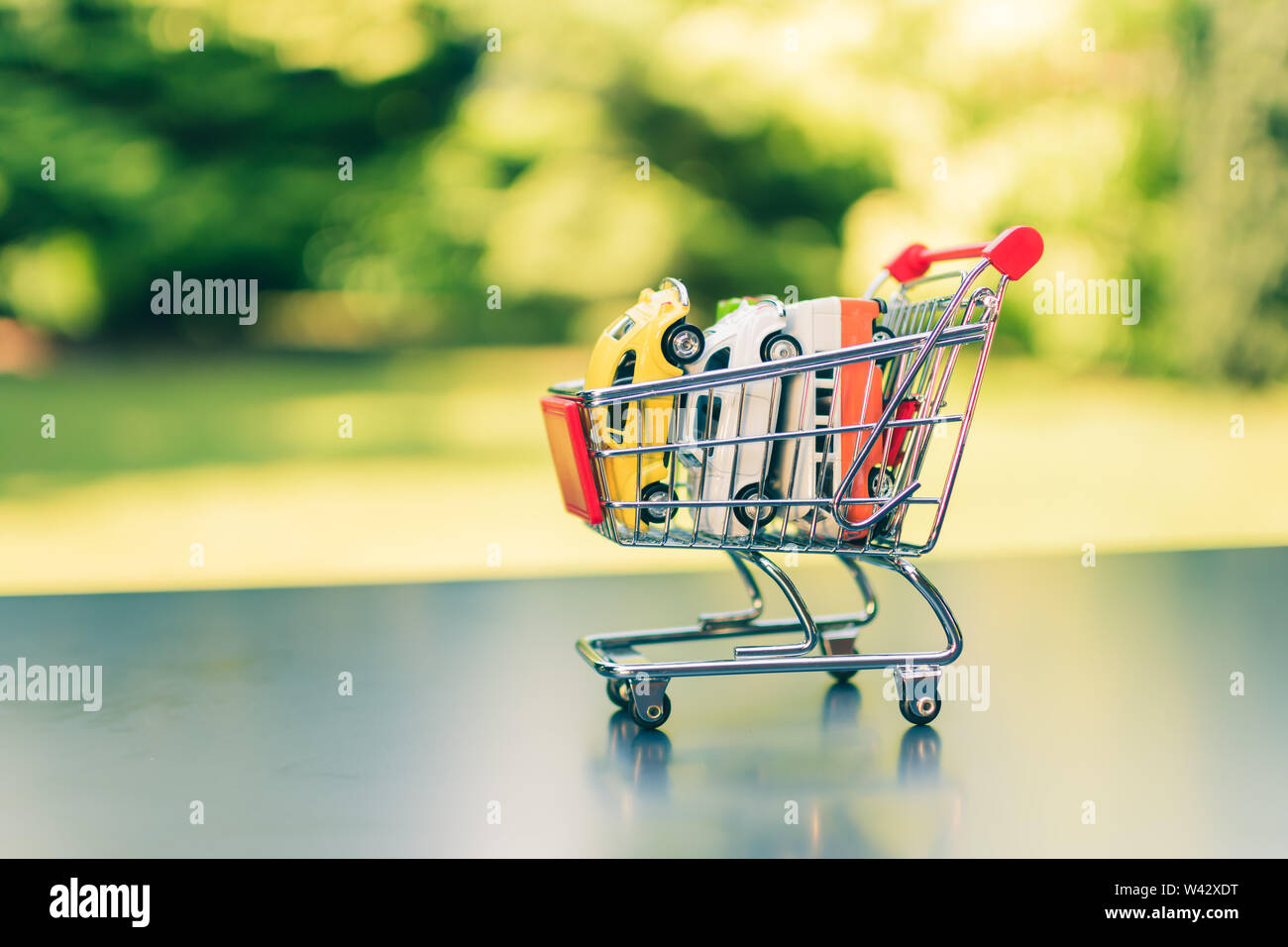 A miniature shopping cart full of cars Stock Photo - Alamy
