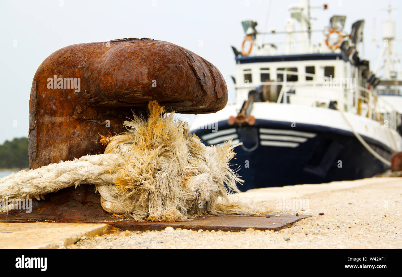 Metal mooring post on the edge of concrete bank of harbor Stock Photo ...