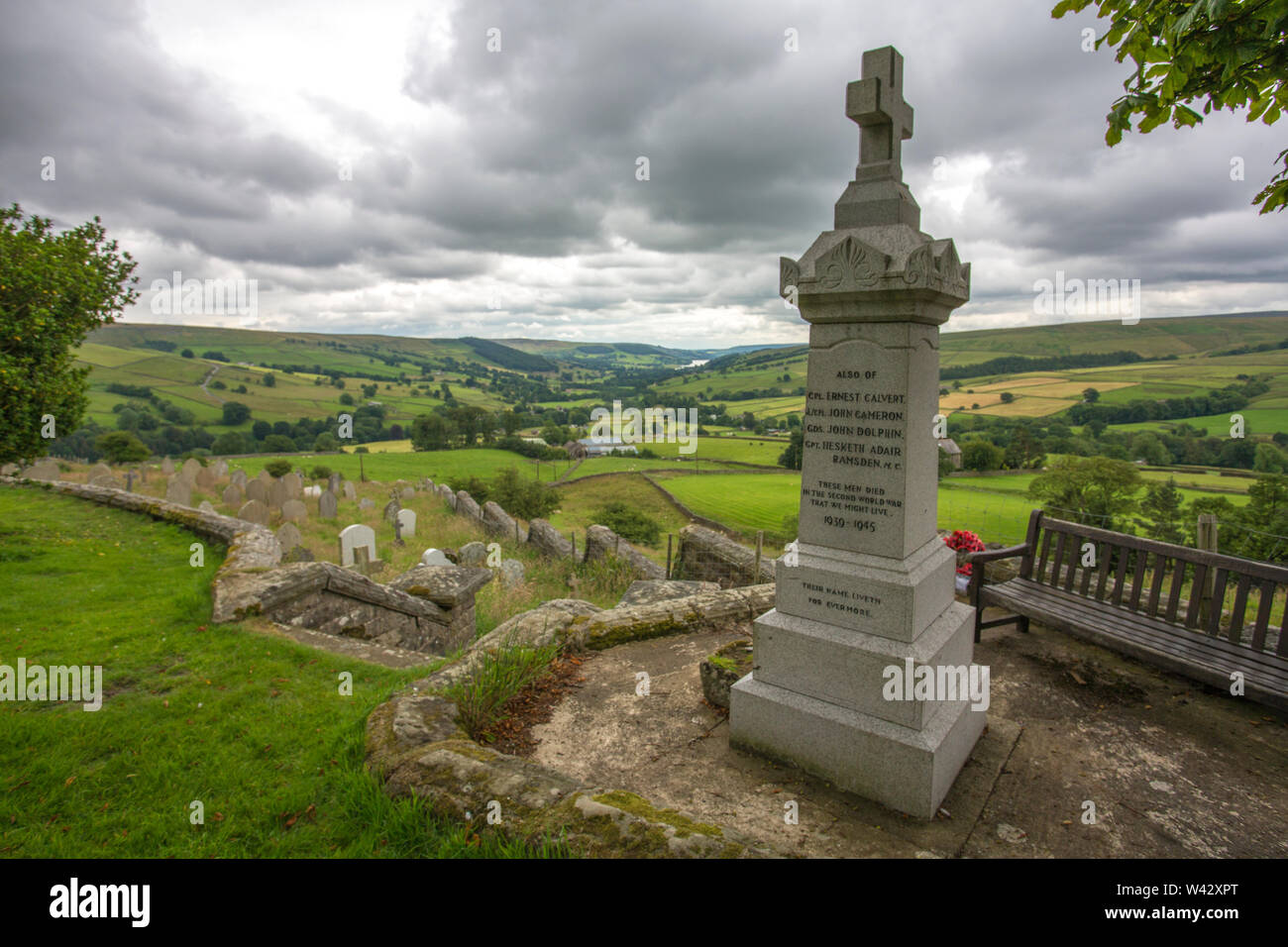 A view across the churchyard of Middlesmoor Church with a WW2 memorial ...