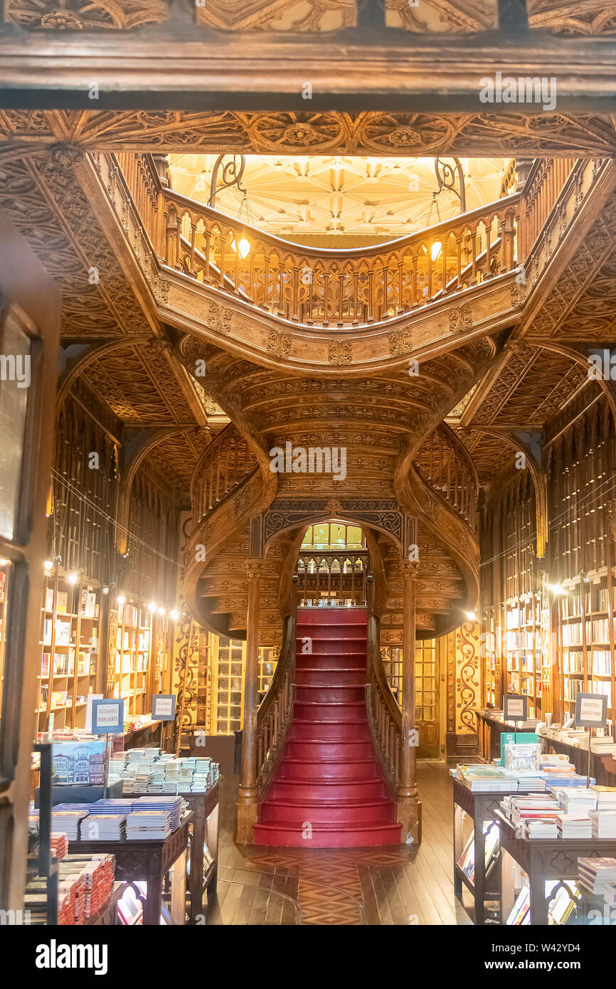 Large wooden staircase with red steps inside Library Lello and Irmao in ...