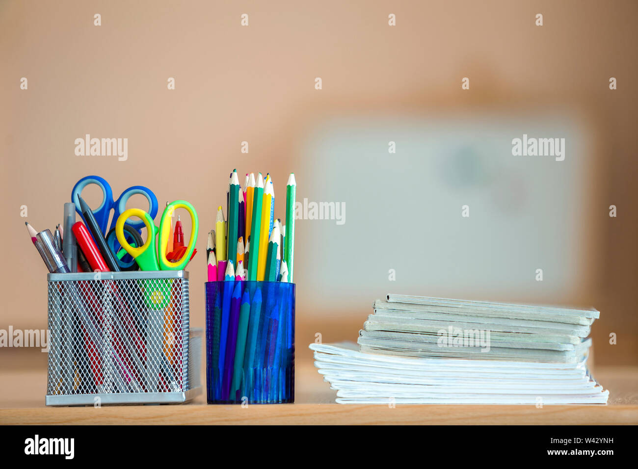 Stack of notebooks, colorful drawing pencils and stationery arrangement ...