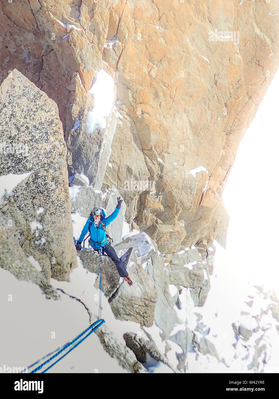 A woman alpinist flashes a Victory sign while on rappel Stock Photo - Alamy