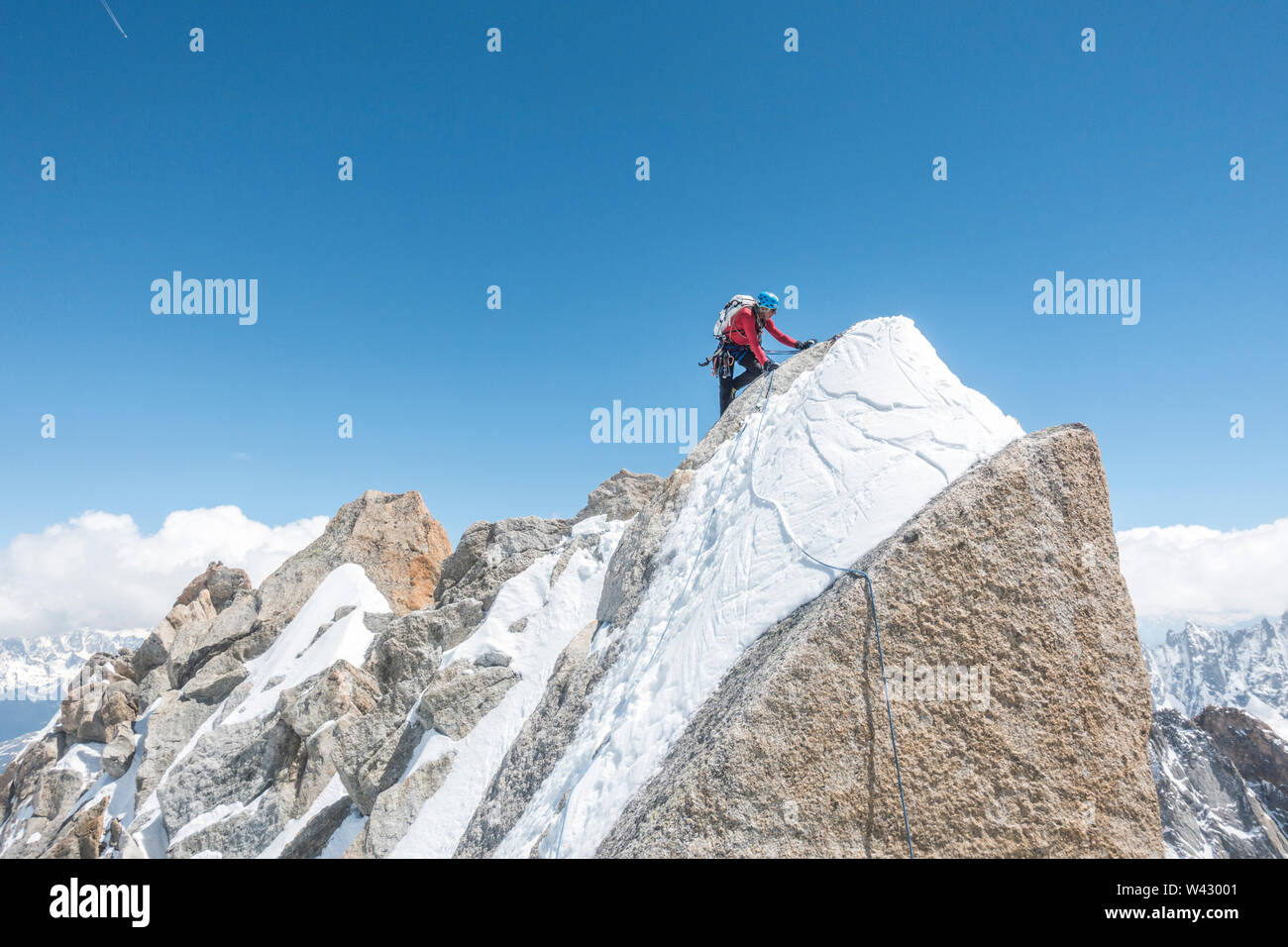 Alpinist in red shirt high up on a mixed terrain alpine ridge Stock ...
