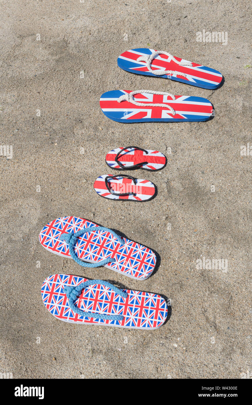 GB flag / Union Jack flip-flops on sandy beach. For UK staycation ...
