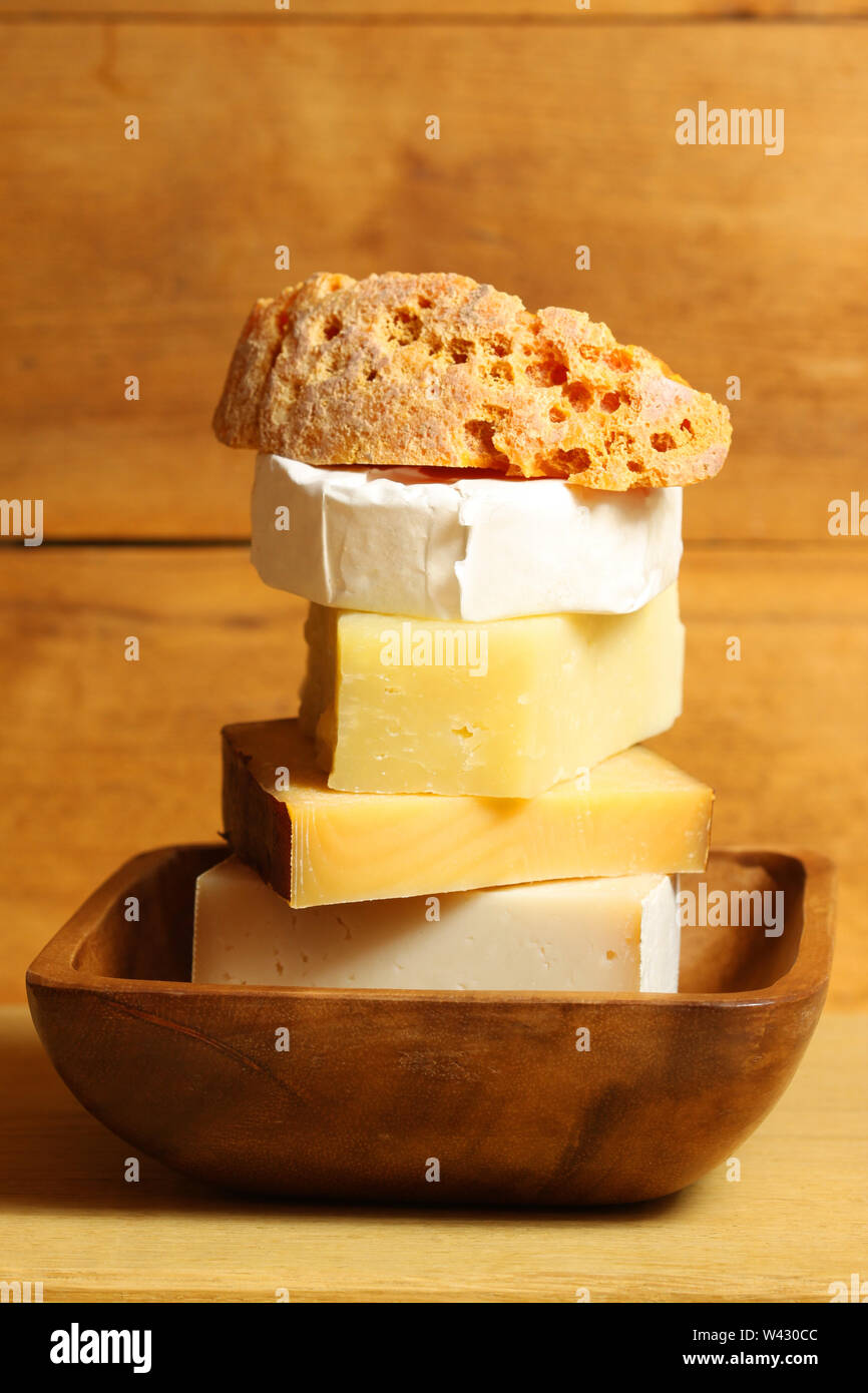 Cheese tower - various kinds in wooden bowl. Vertical Stock Photo - Alamy