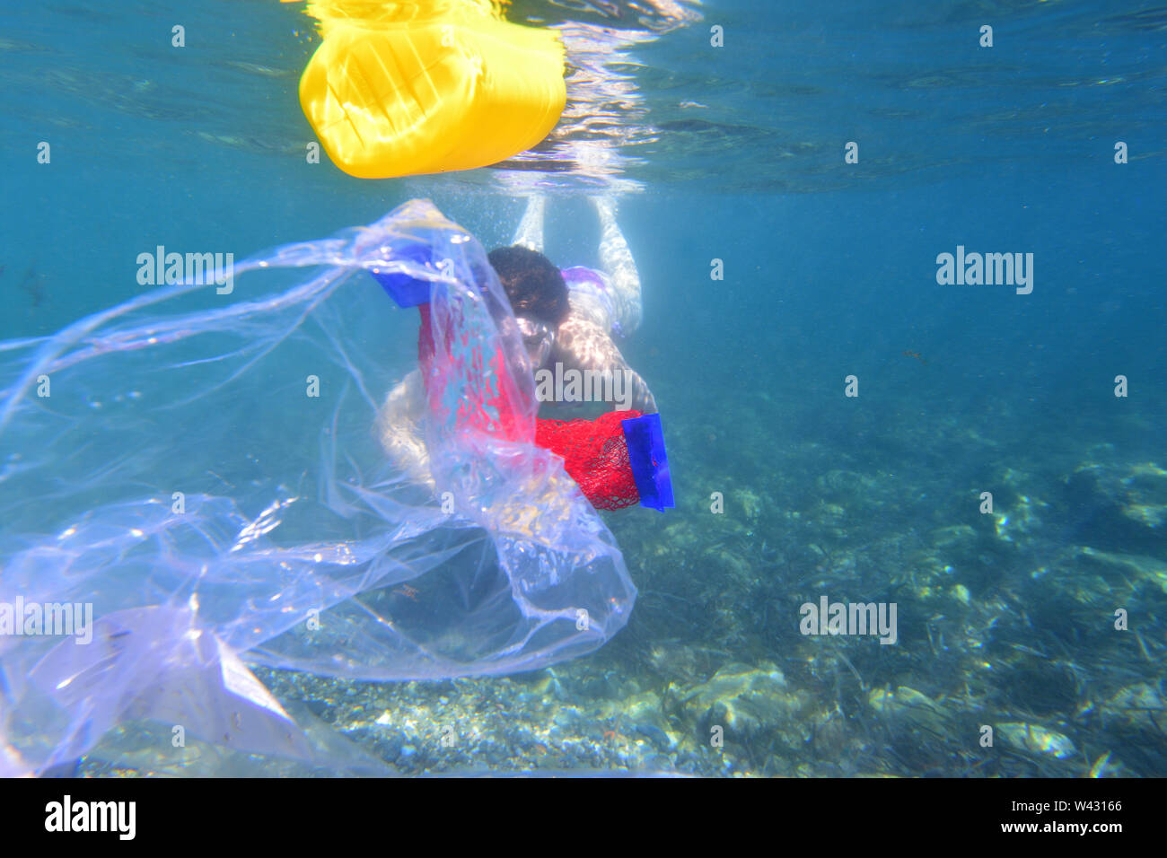 woman diving in the sea with garbage, plastic Stock Photo - Alamy