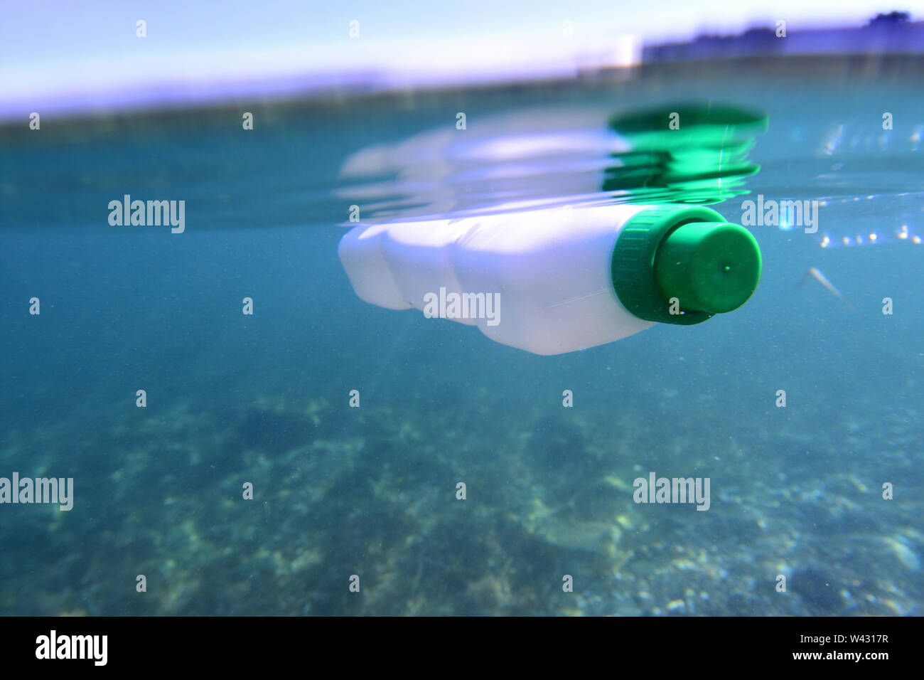 plastic bottle floating in the sea, photo underwater with the seabed ...
