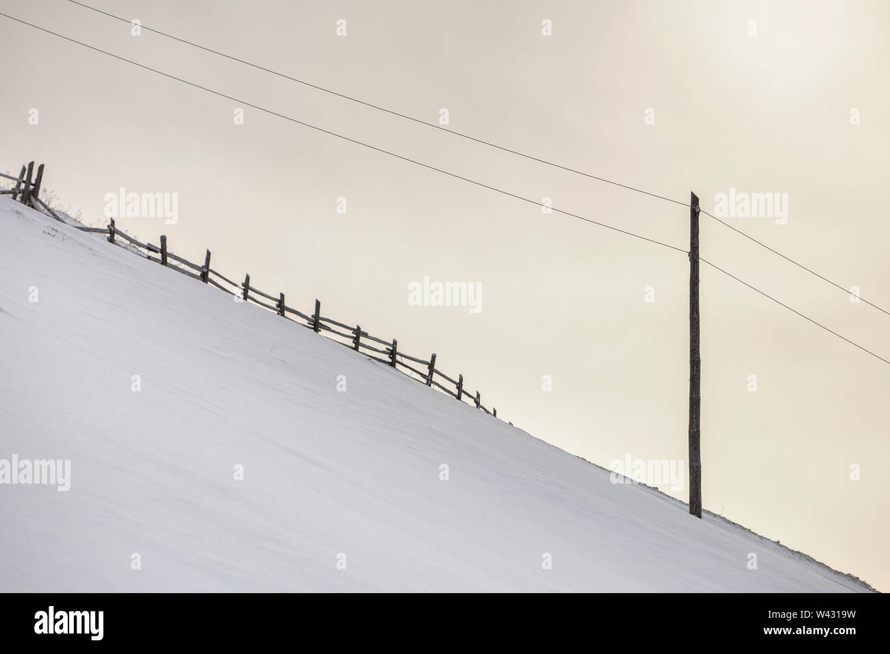 Winter landscape. Steep mountain slope with electrical current line on ...