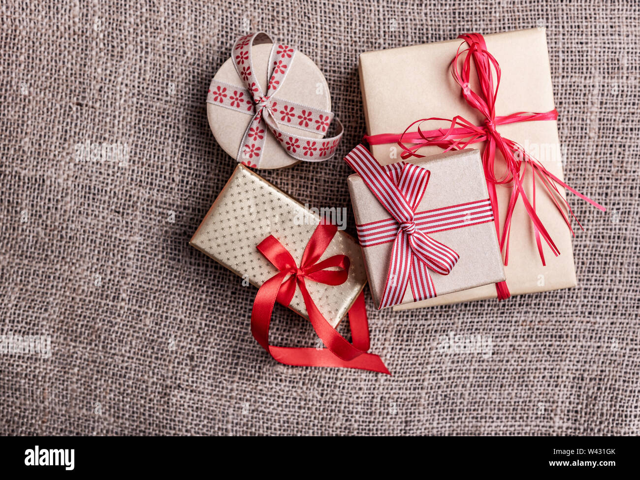 Christmas boxes with gifts on burlap background Stock Photo - Alamy