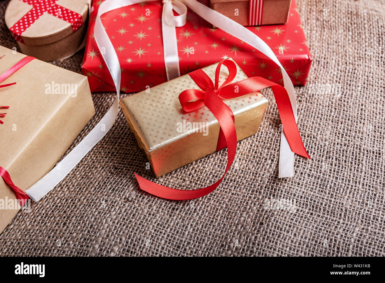 Christmas boxes with gifts on burlap background Stock Photo - Alamy