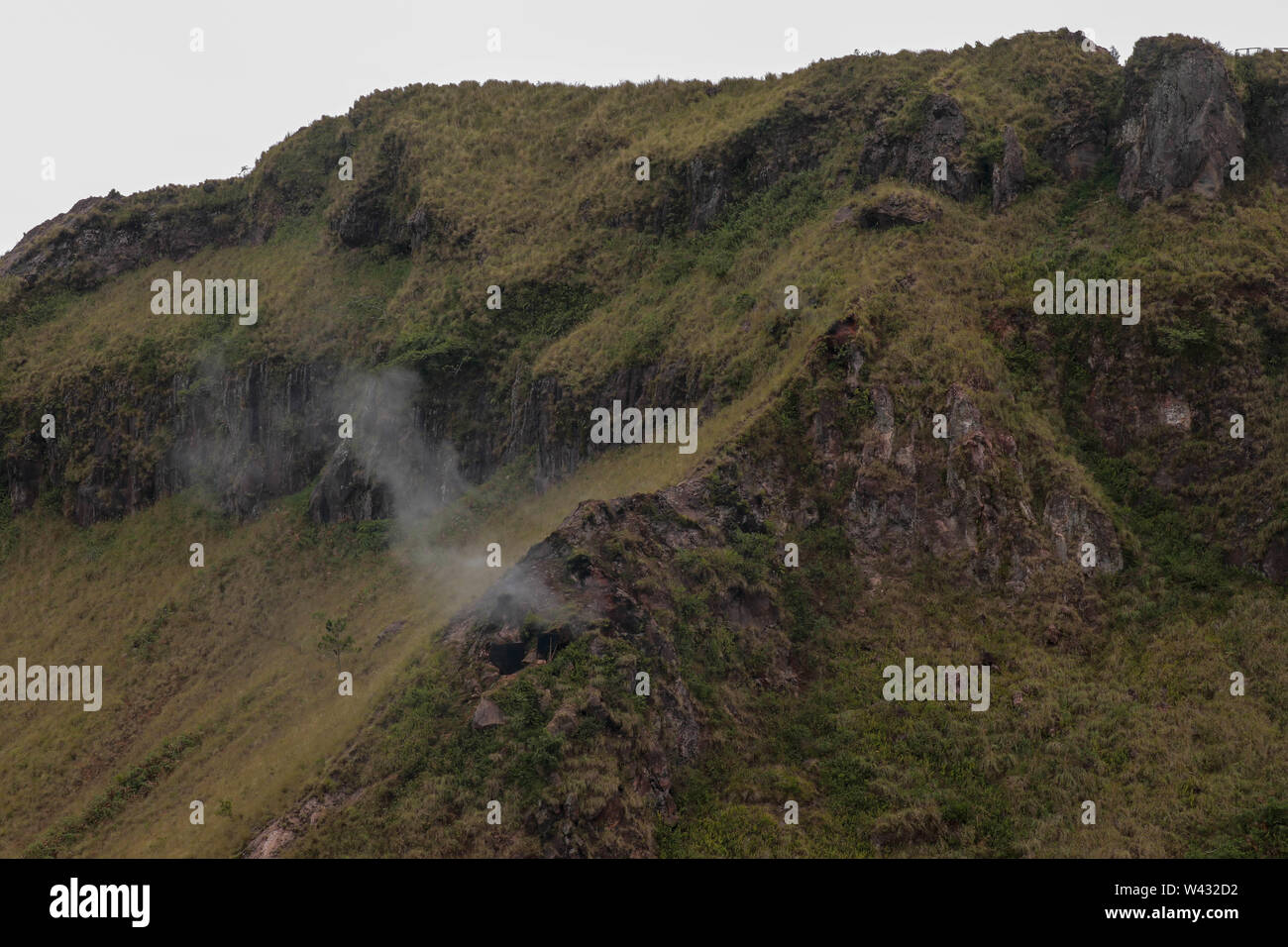 Smoke rises from a volcanic flue in the Batur Crater. Geological ...