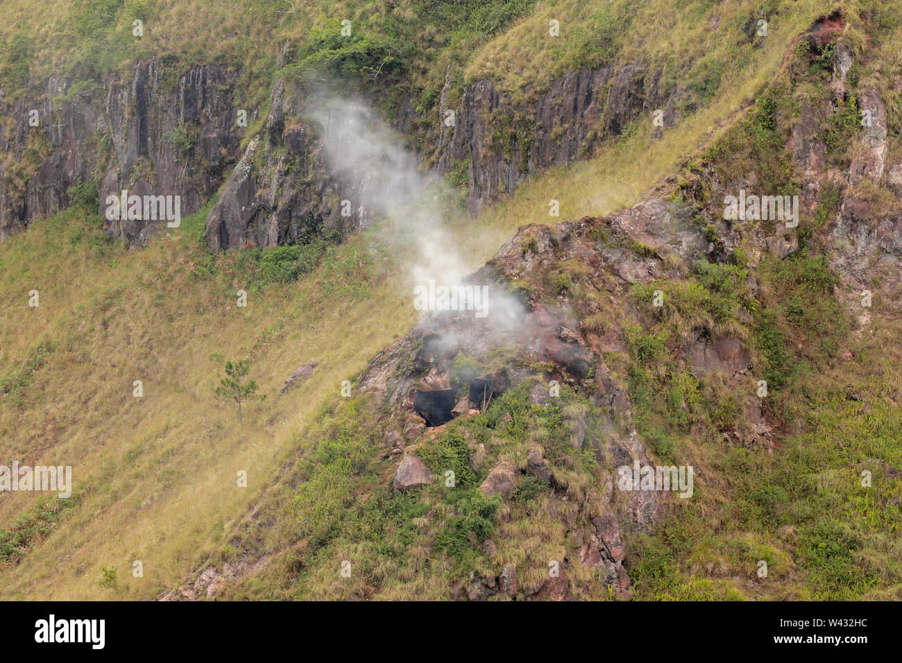 Smoke rises from a volcanic flue in the Batur Crater. Geological ...