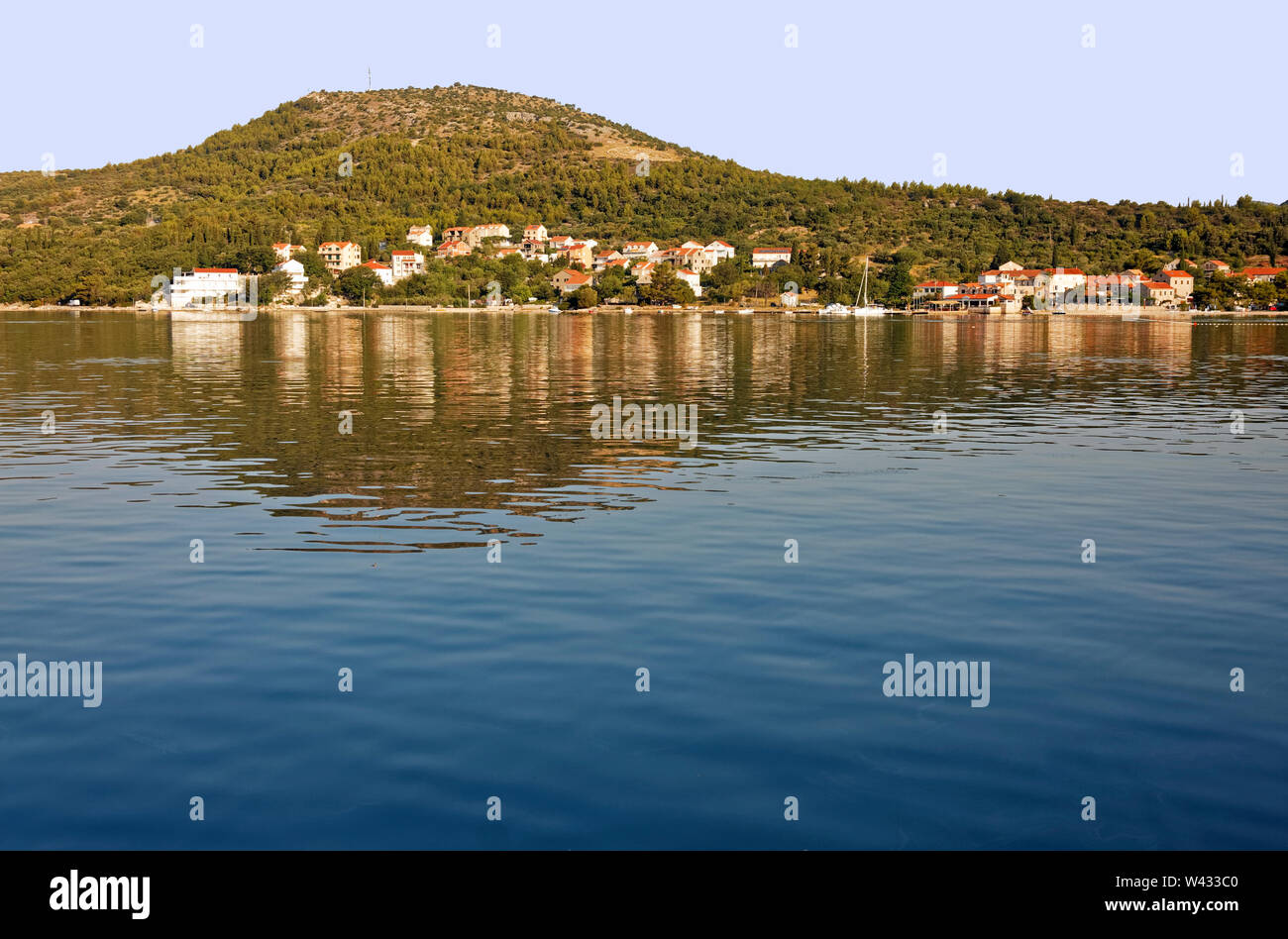 marine scene; town buildings clustered, hill; reflections, Adriatic Sea ...
