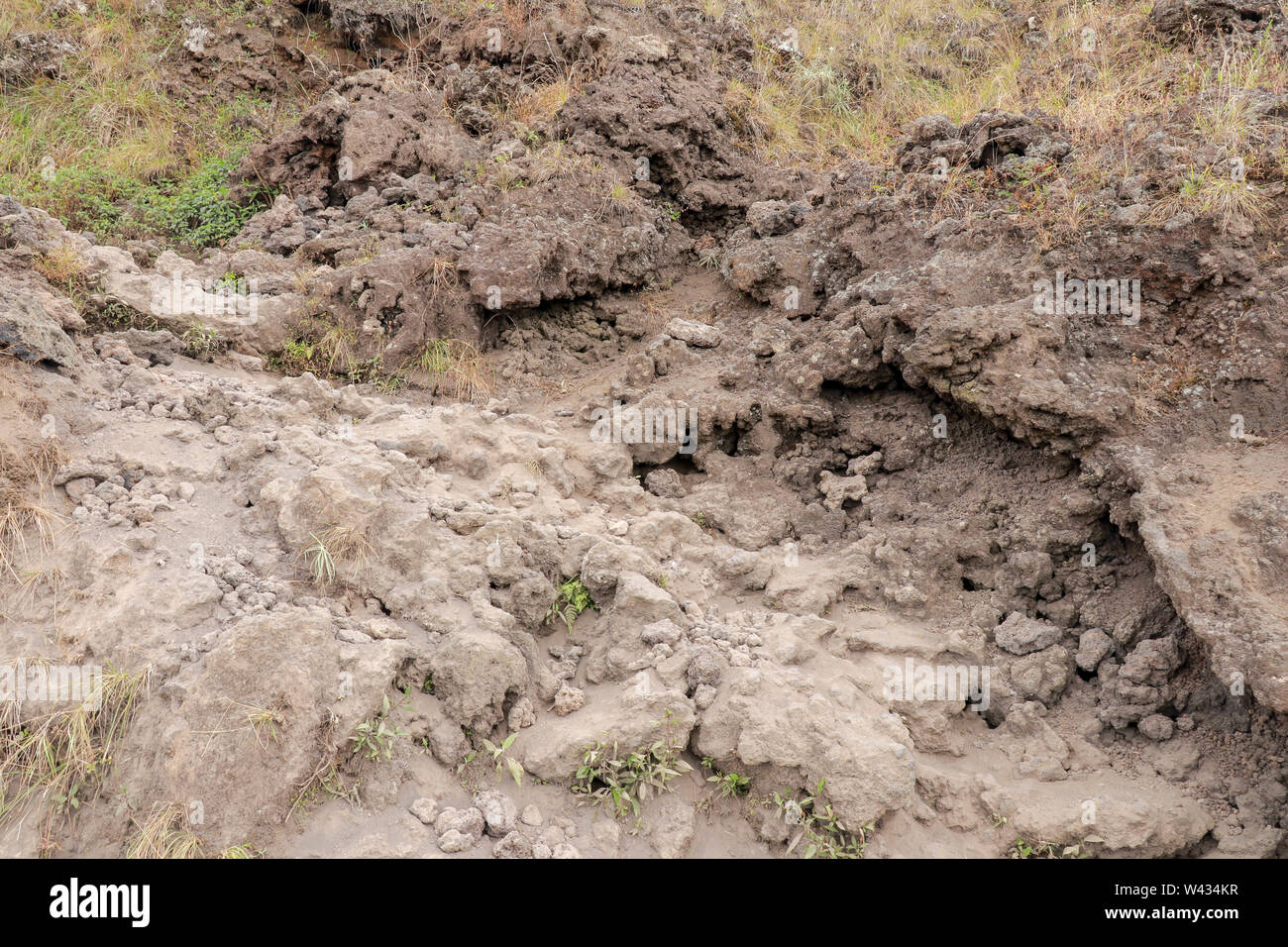 Dusty lava flow trail to the top of Batur volcano on Bali island. Slag ...