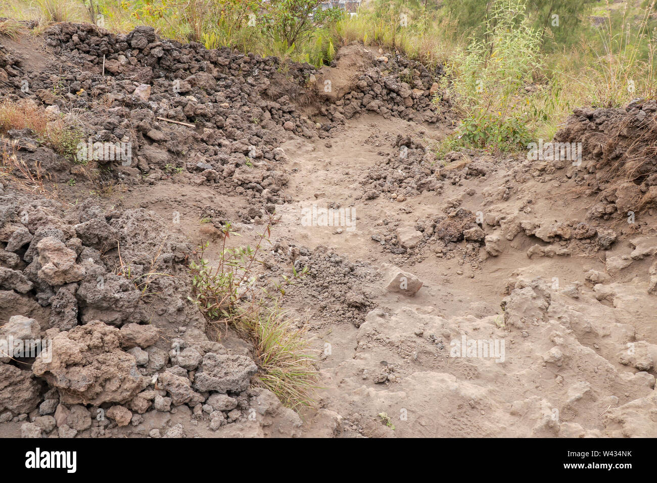 Dusty lava flow trail to the top of Batur volcano on Bali island. Slag ...