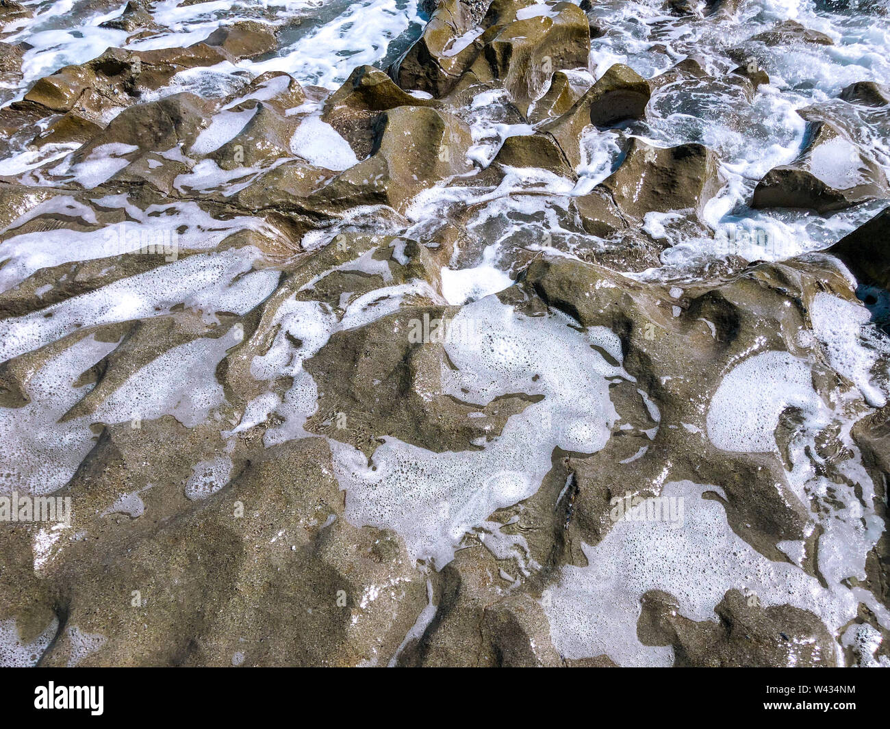 Stones by the sea of fancy shape and color. Foamy surf of the sea Stock ...