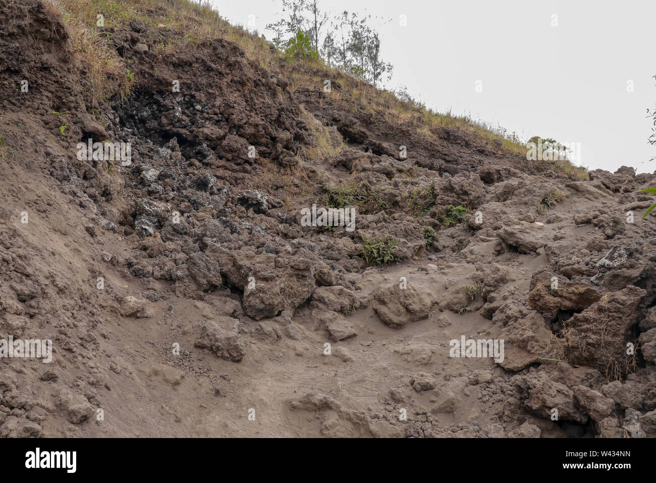 Dusty lava flow trail to the top of Batur volcano on Bali island. Slag ...