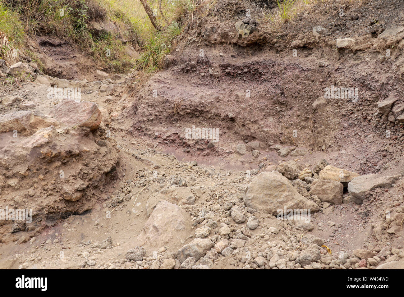 Dusty lava flow trail to the top of Batur volcano on Bali island. Slag ...