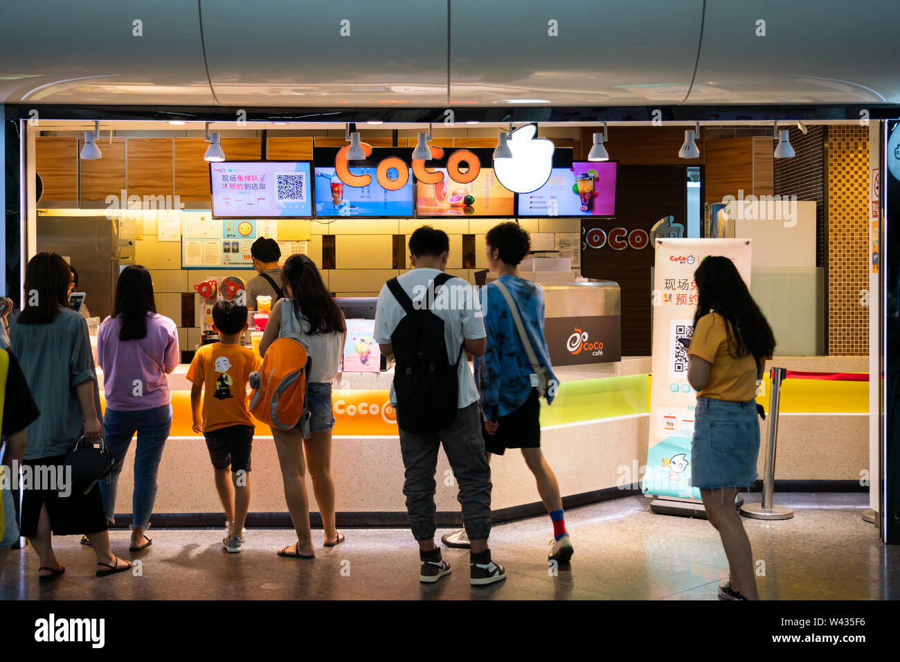 Customers stand in front Chinese beverage chain CoCo Fresh Tea & Juice ...