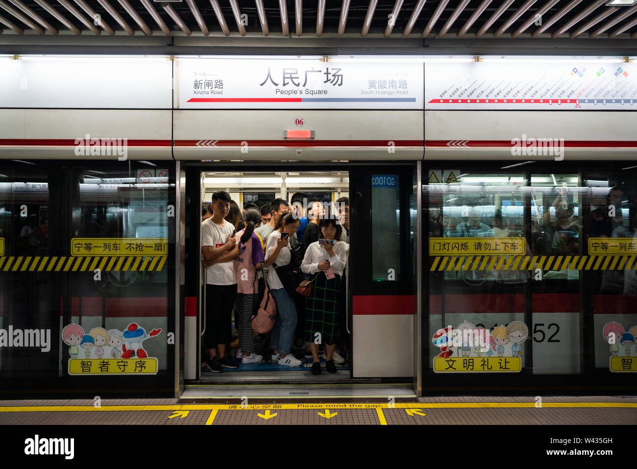 People inside a metro train stopping at People's Square Station in ...
