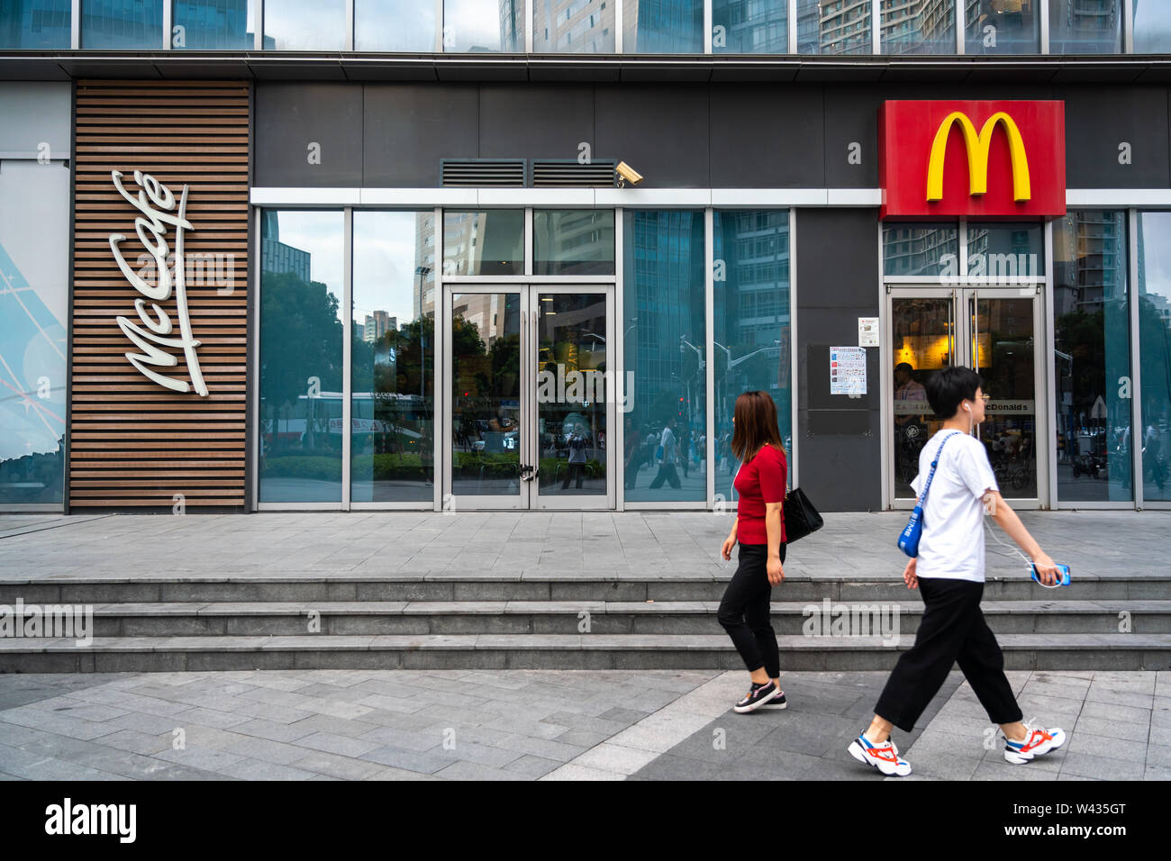 Pedestrians walk past an American fast food company McDonald's ...