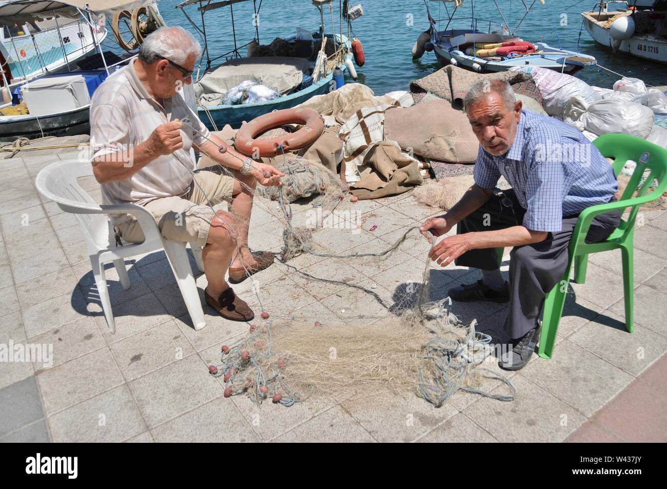 Fishermen unravelling their net on the quayside, Fethiye, Turkey Stock ...