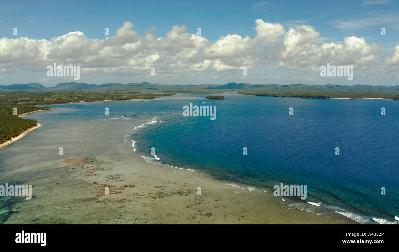 Seascape with the coast of the tropical island covered with forest and ...