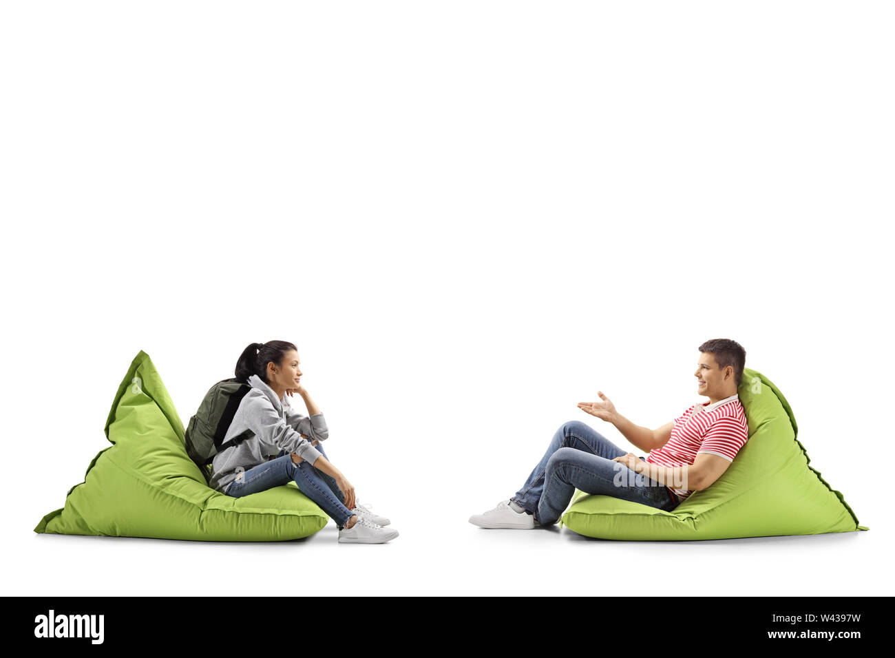 Full length profile shot of a female student and a young man sitting on ...
