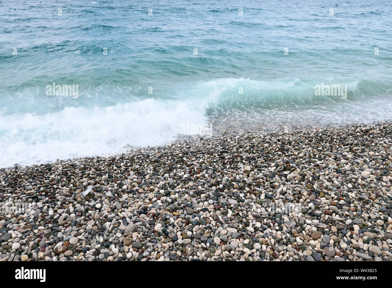 Pebble beach and blue sea Stock Photo - Alamy