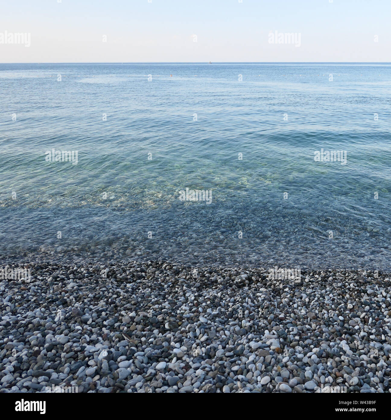 Pebble beach and blue sea Stock Photo - Alamy