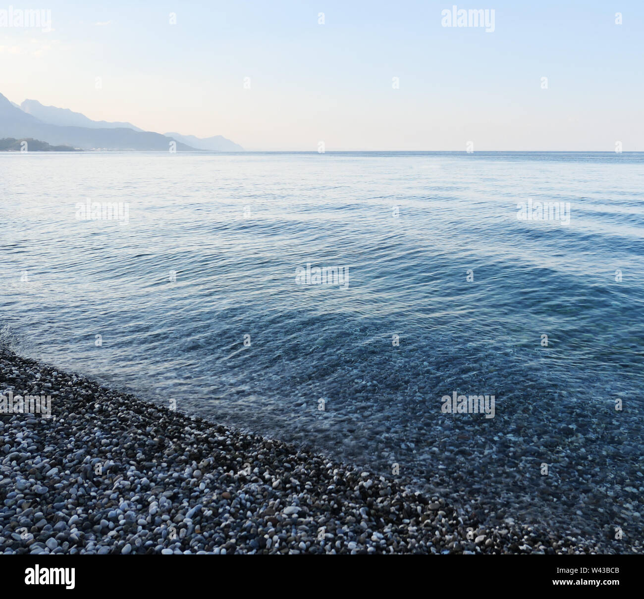 Pebble beach and blue sea Stock Photo - Alamy