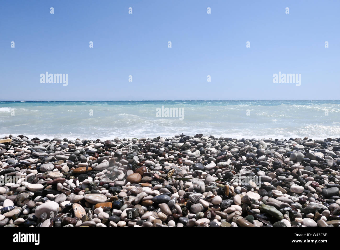 Pebble beach and blue sea Stock Photo - Alamy
