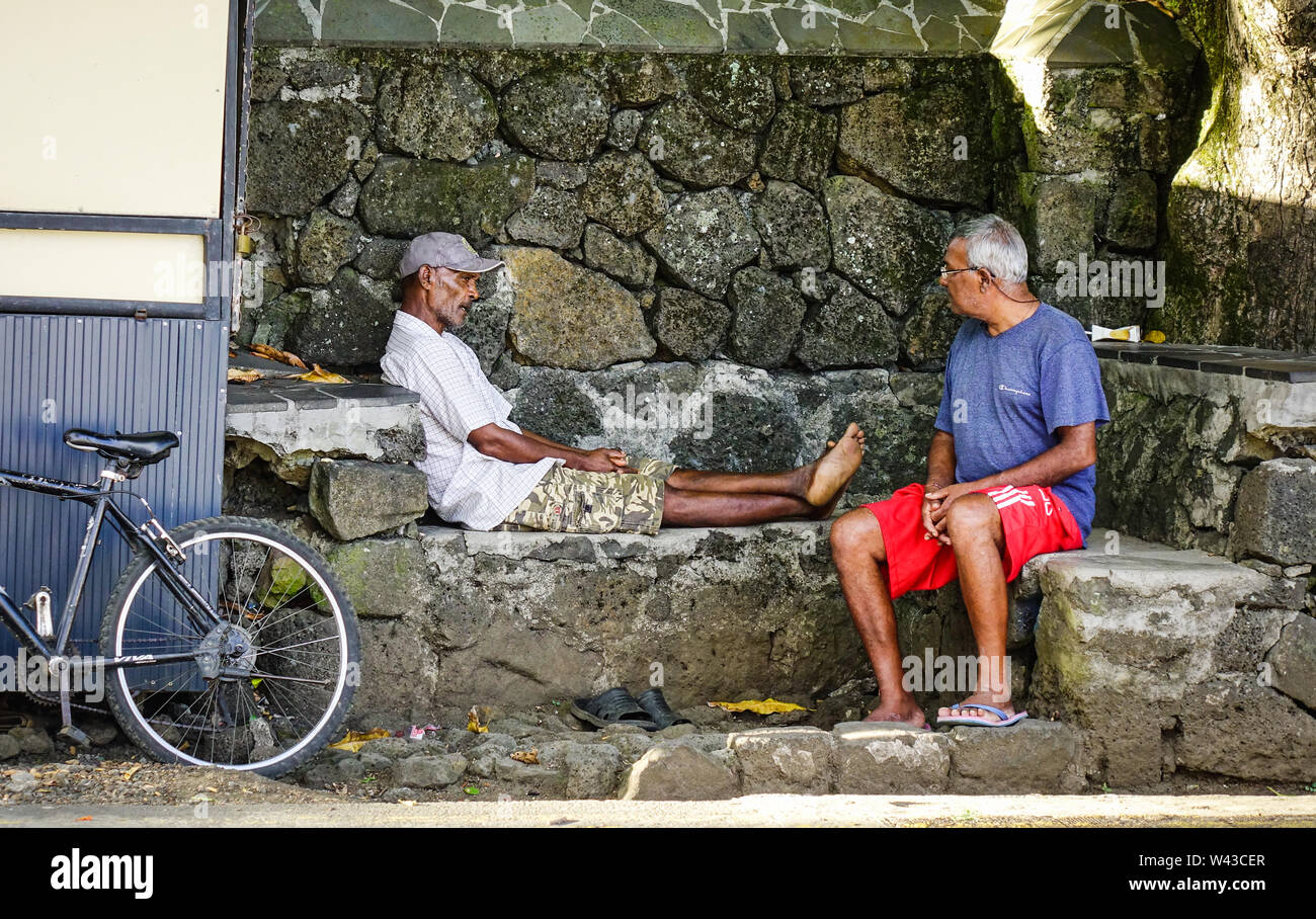 Grand Baie, Mauritius - Jan 11, 2017. Old men sitting and chatting in ...