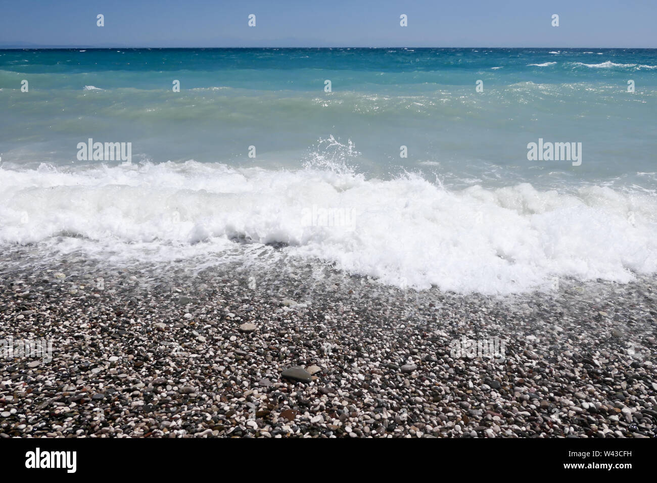 Pebble beach and blue sea Stock Photo - Alamy