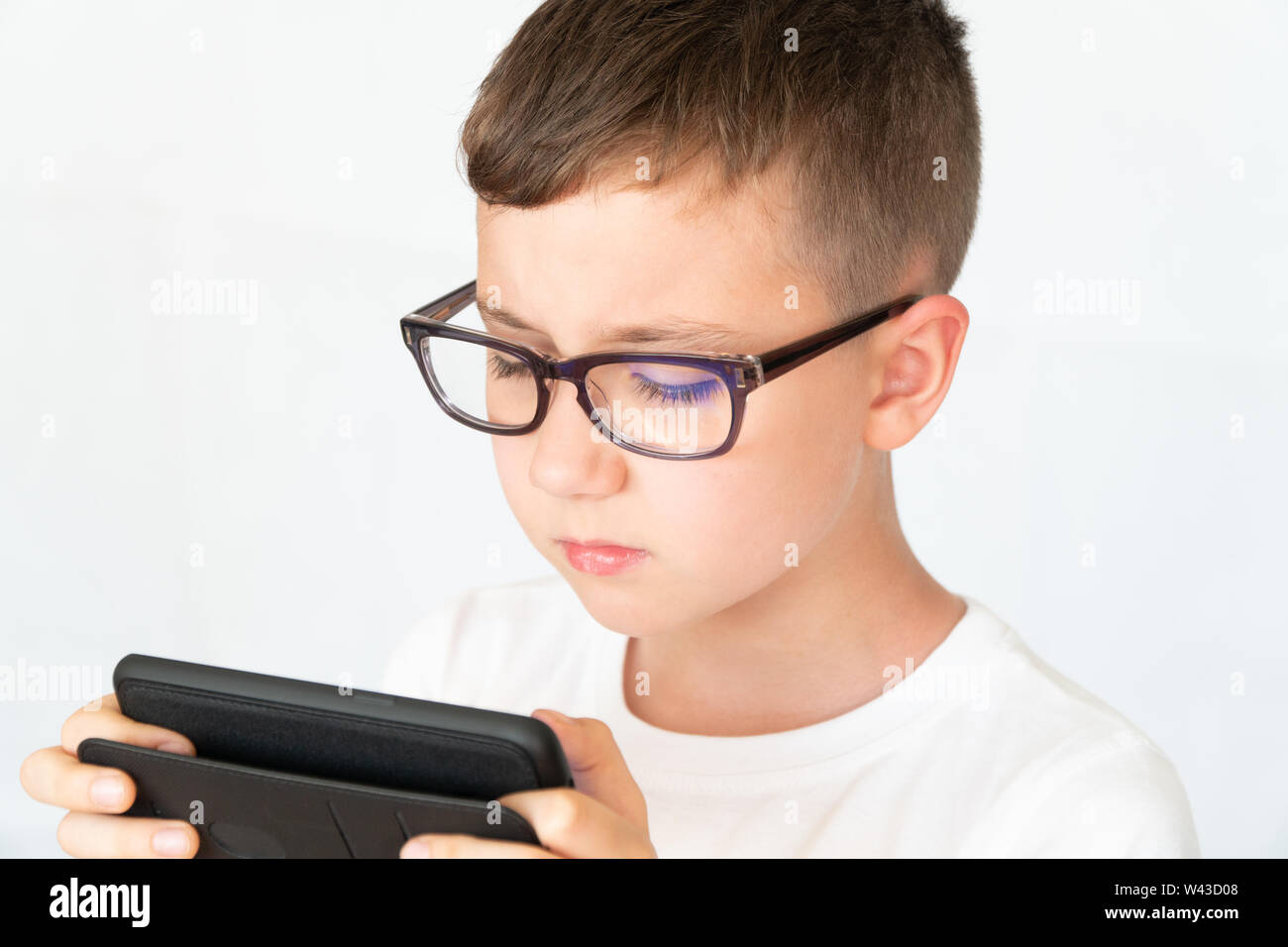 little boy looks handsome smartphone video, in glasses, dressed in ...