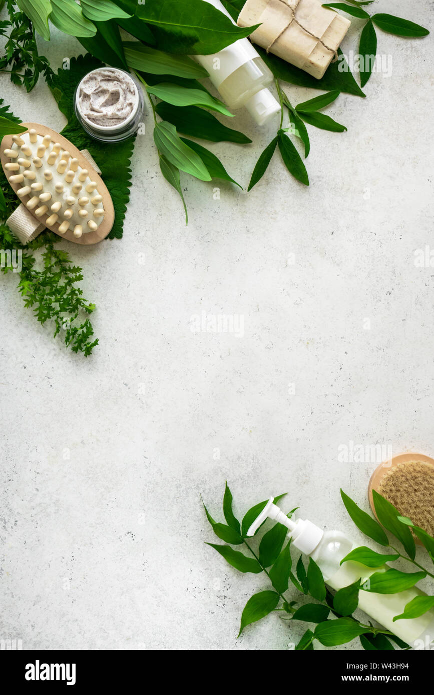 Natural cosmetics and green leaves on white stone background, copy ...