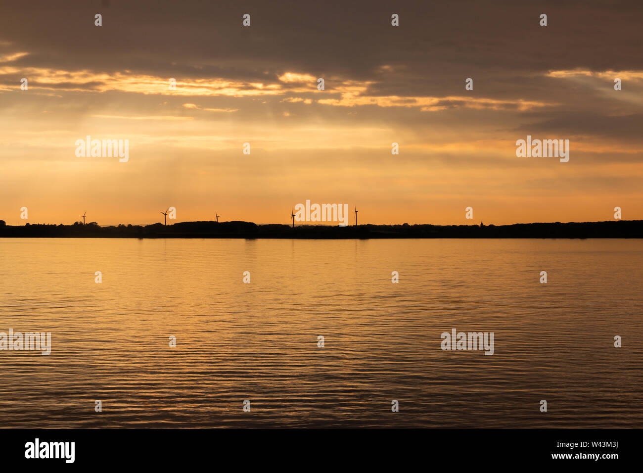 Beautiful sunset at the Kattegat sea, with mind mills in the background ...