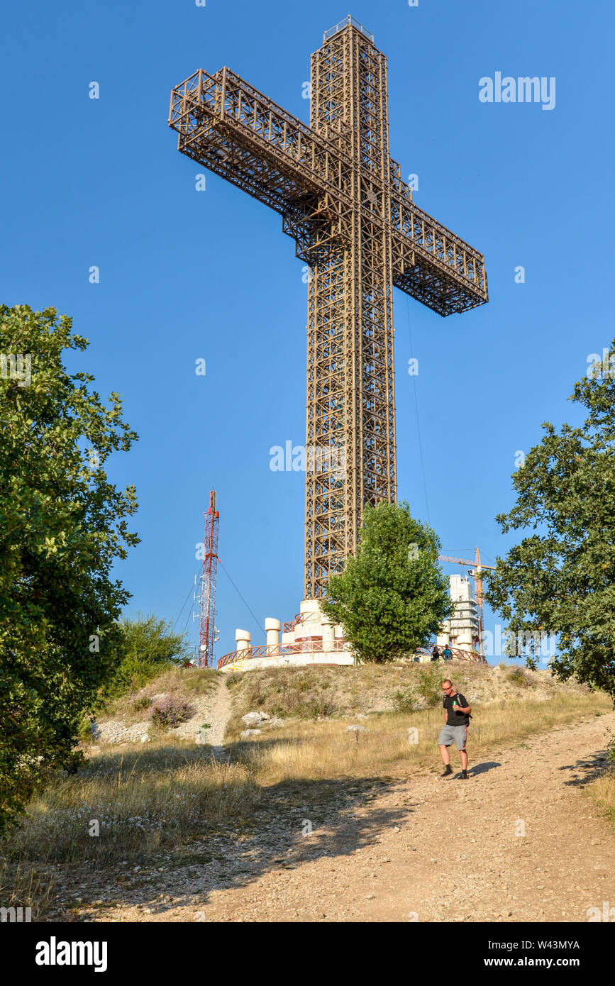 Man walks beneath the Millennium Cross in Skopje, a 66 meter tall cross ...