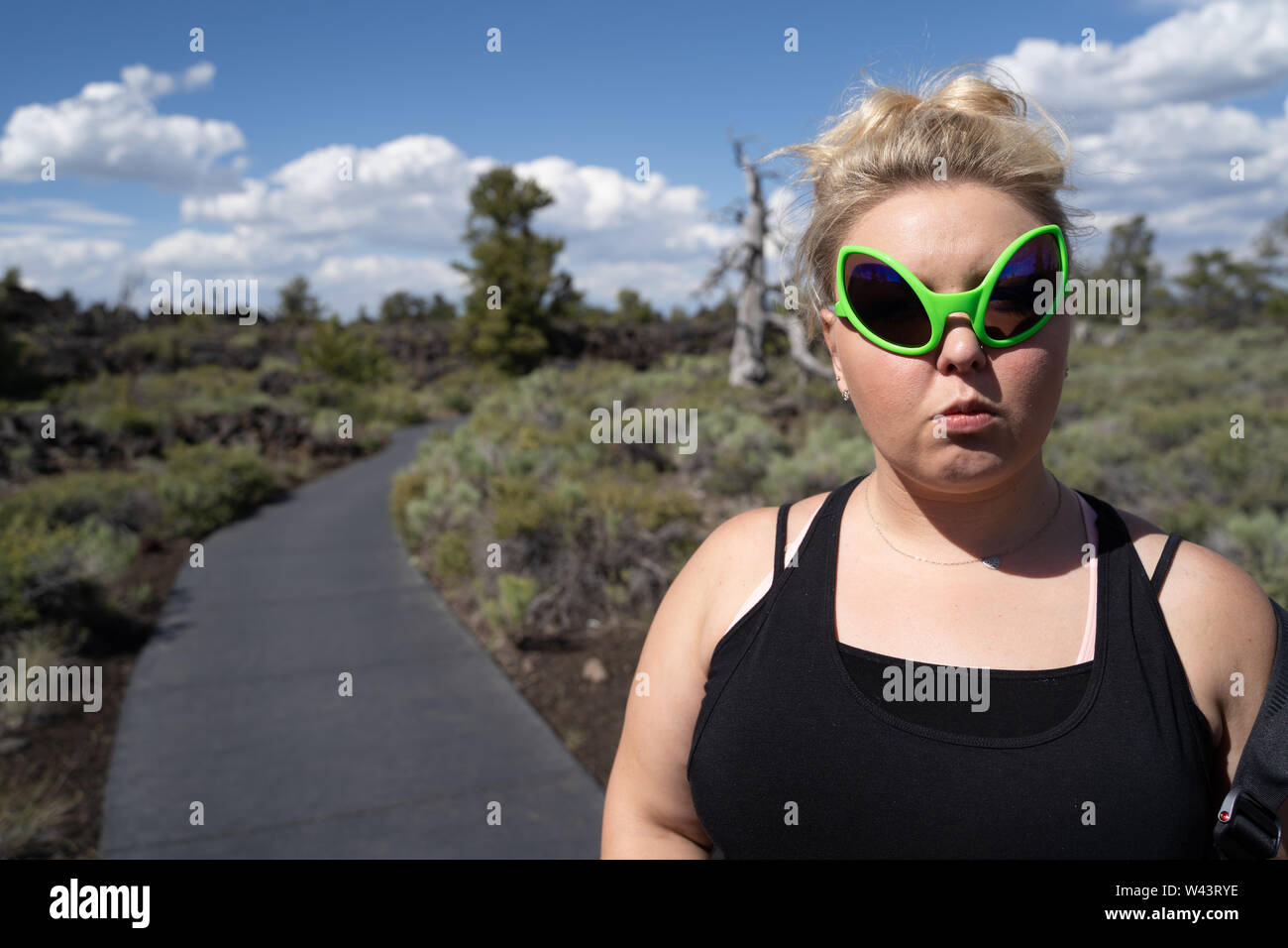 Blonde woman wearing alien sunglasses poses at Craters of the Moon ...