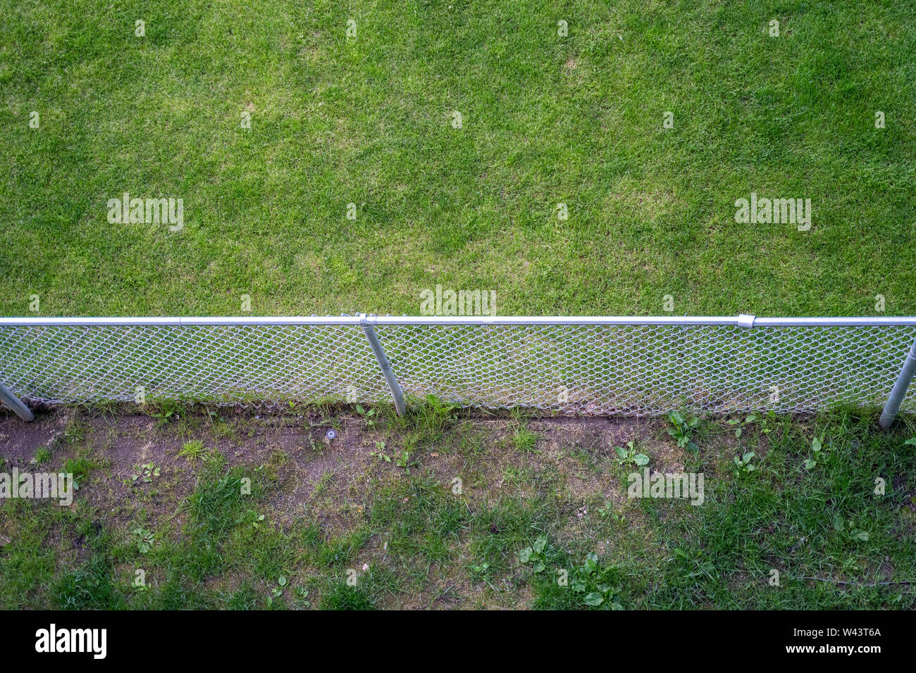 Aerial view of a metal chain link fence with grass on each side Stock ...