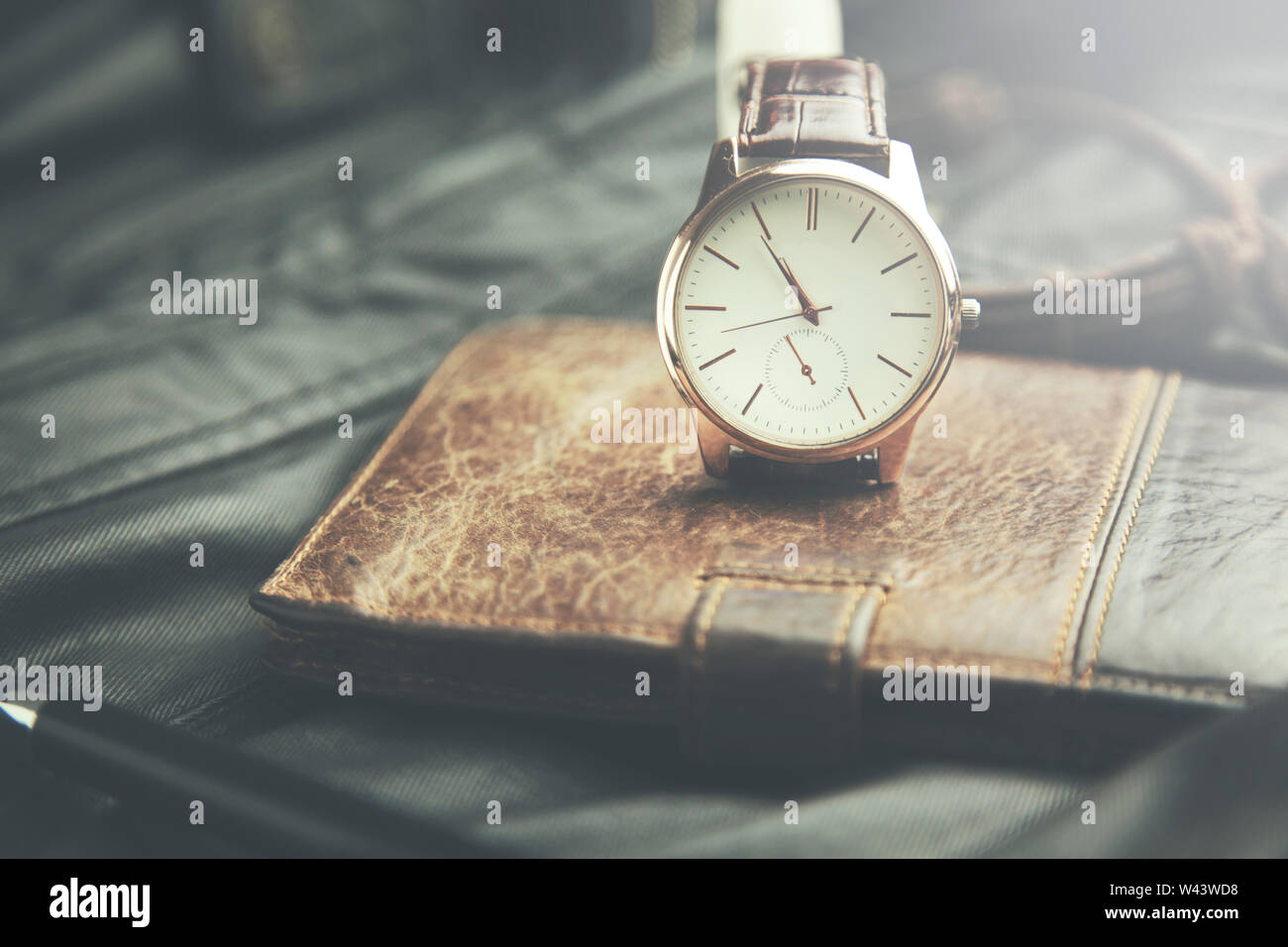 watch on wallet on leather background Stock Photo - Alamy