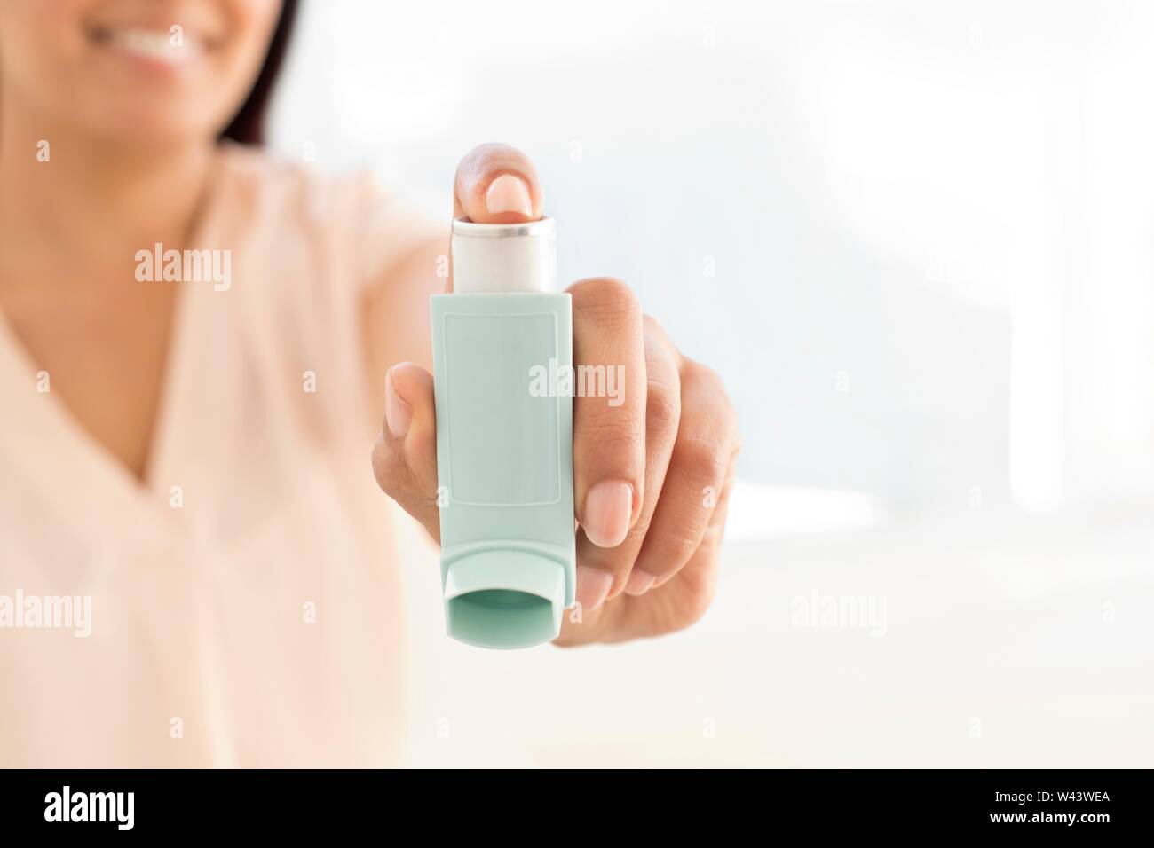 Woman holding inhaler Stock Photo - Alamy