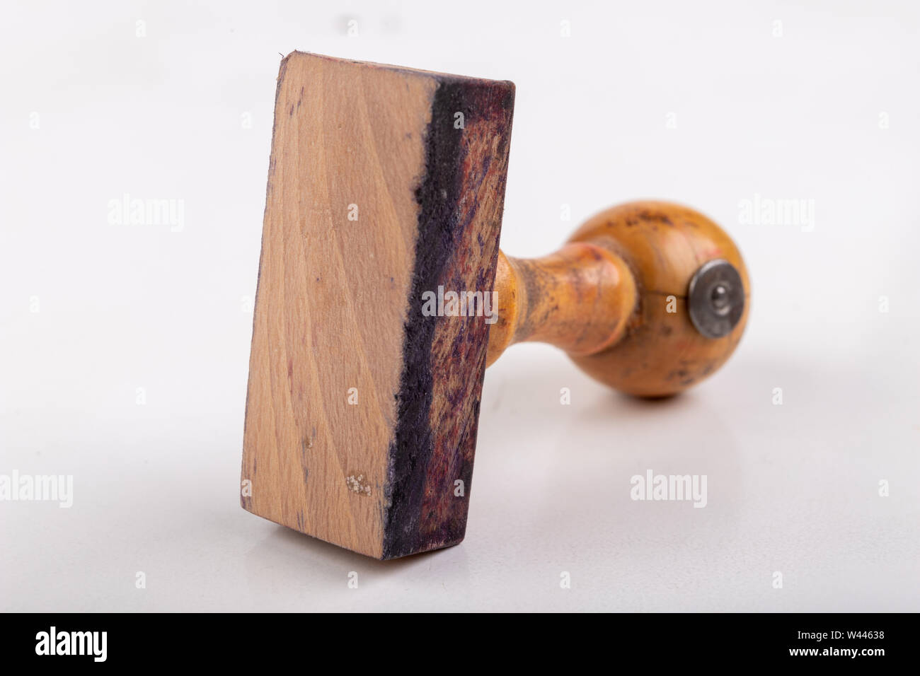 An old wooden stamp used in the office. Blank stamp on a white table ...