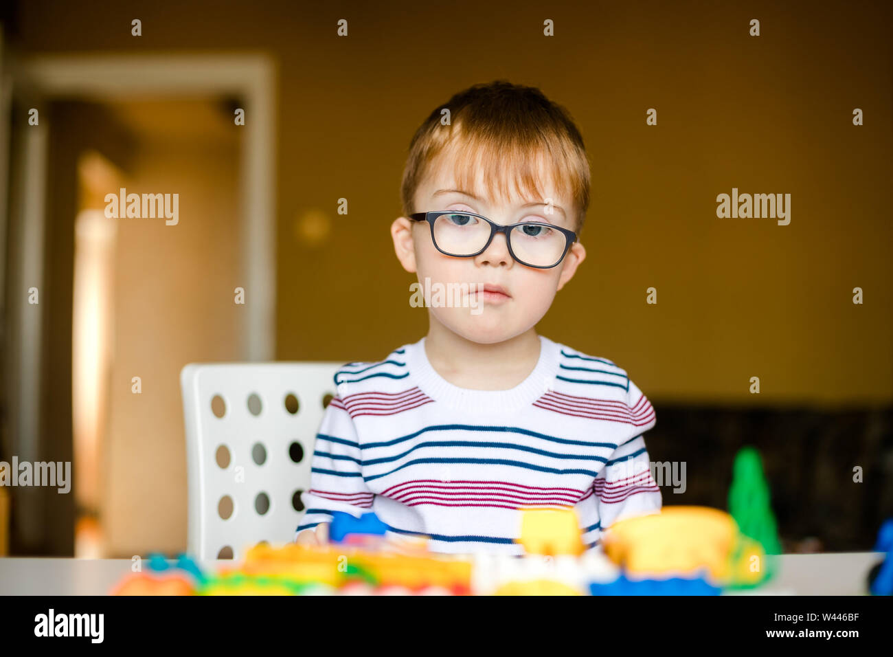 little ginger boy with glasses with syndrome dawn playing with color ...