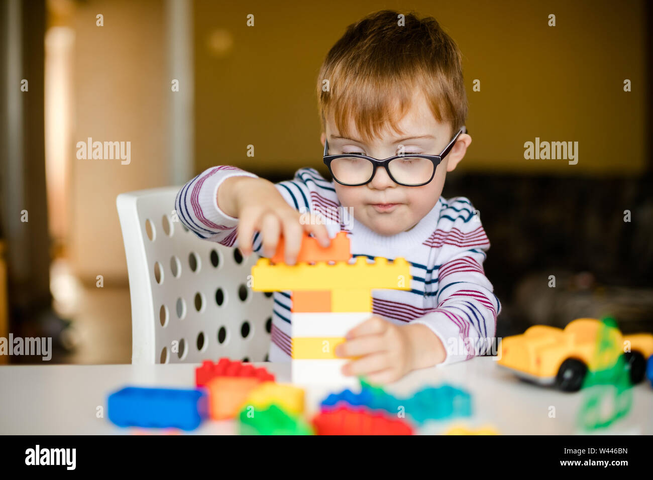 little ginger boy with glasses with syndrome dawn playing with color ...