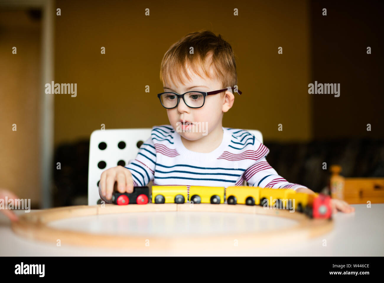 little ginger boy with glasses with syndrome dawn playing with train ...
